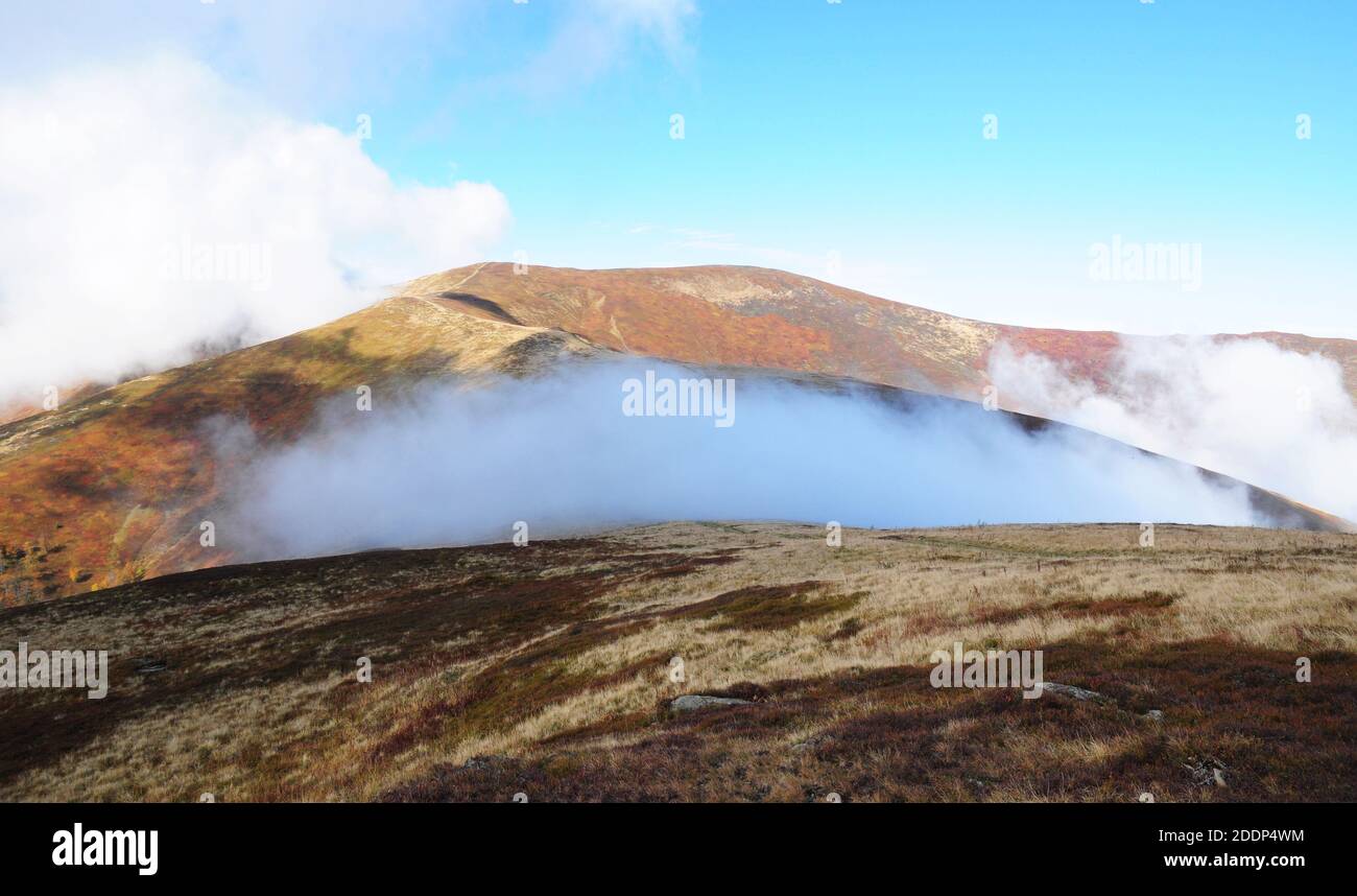 A beautiful autumn mountain landscape that depicts a small white cloud ...