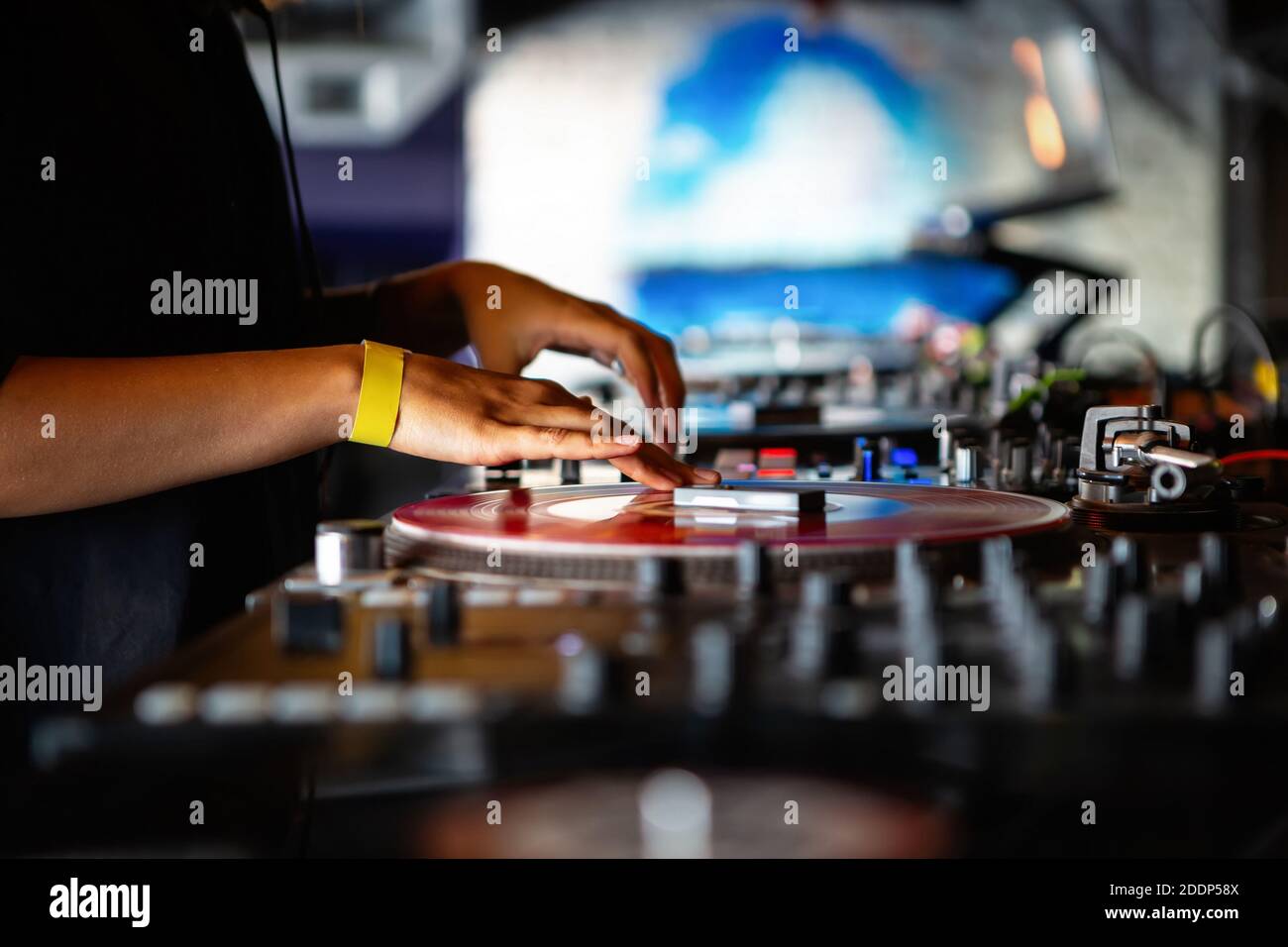 DJ girl playing music in night club with retro turntables & vinyl ...