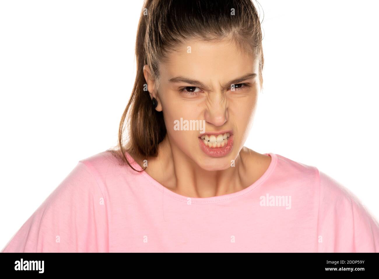 Angry young woman shows her teeth on white background Stock Photo - Alamy
