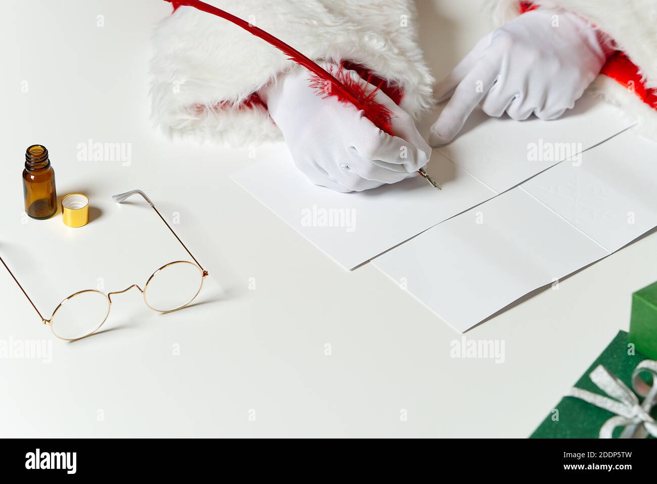 Costumed hands of Santa Claus writing a Christmas letter or greeting on ...