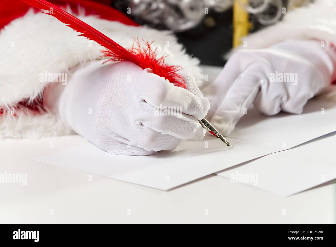 Costumed hands of Santa Claus writing a Christmas letter or greeting on ...