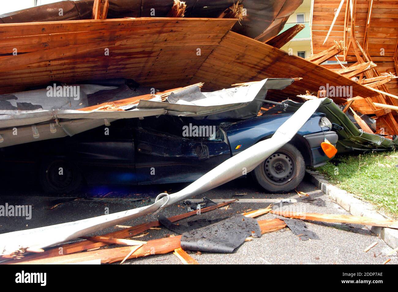 blue car destroyed by a collapsed wooden building, storm damage Stock ...