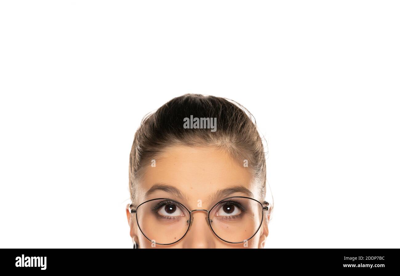 Half portrait of young puzzled woman with glasses, looking up on white ...