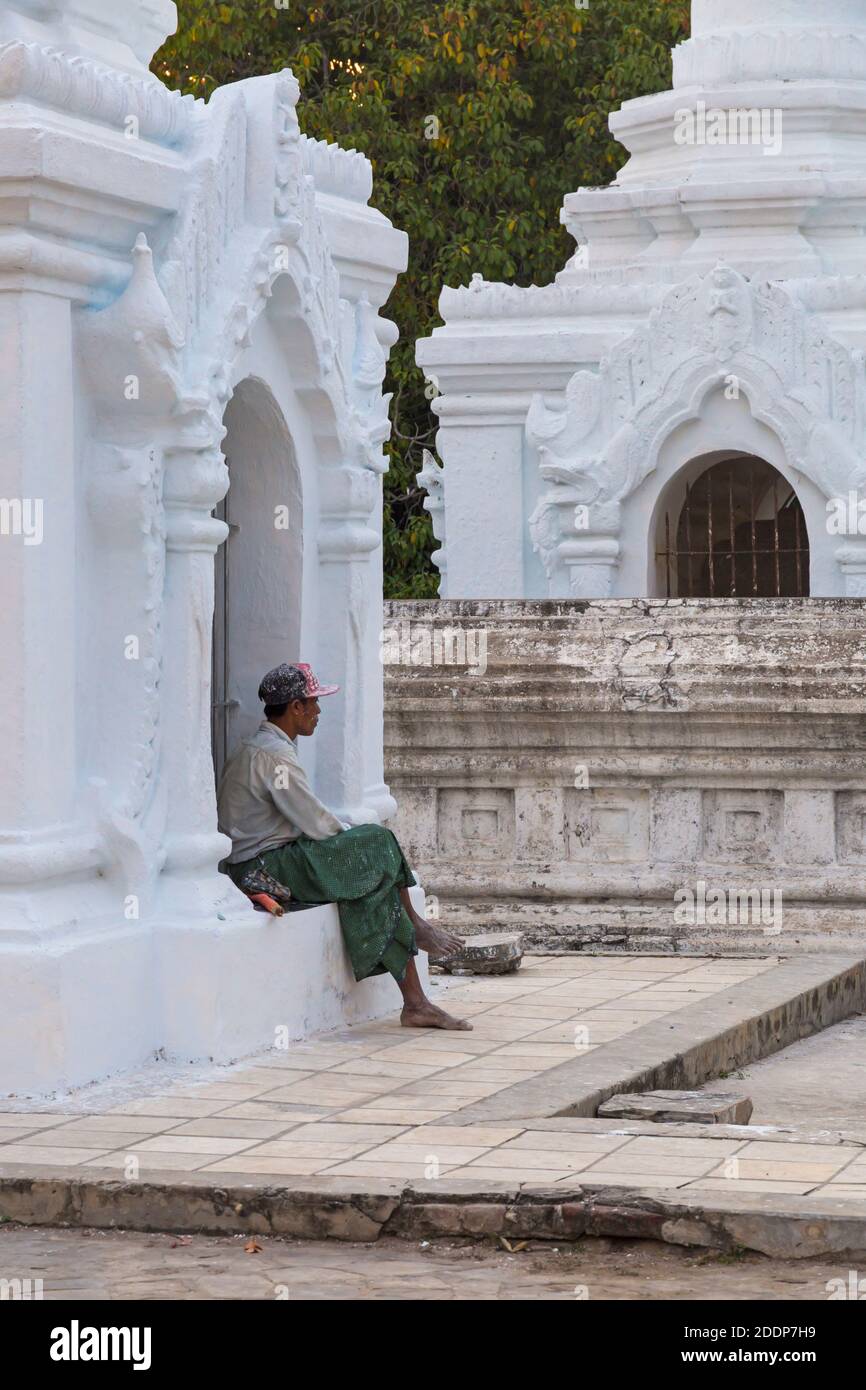 Man sitting down covered in splashes of paint at Kuthodaw Pagoda ...