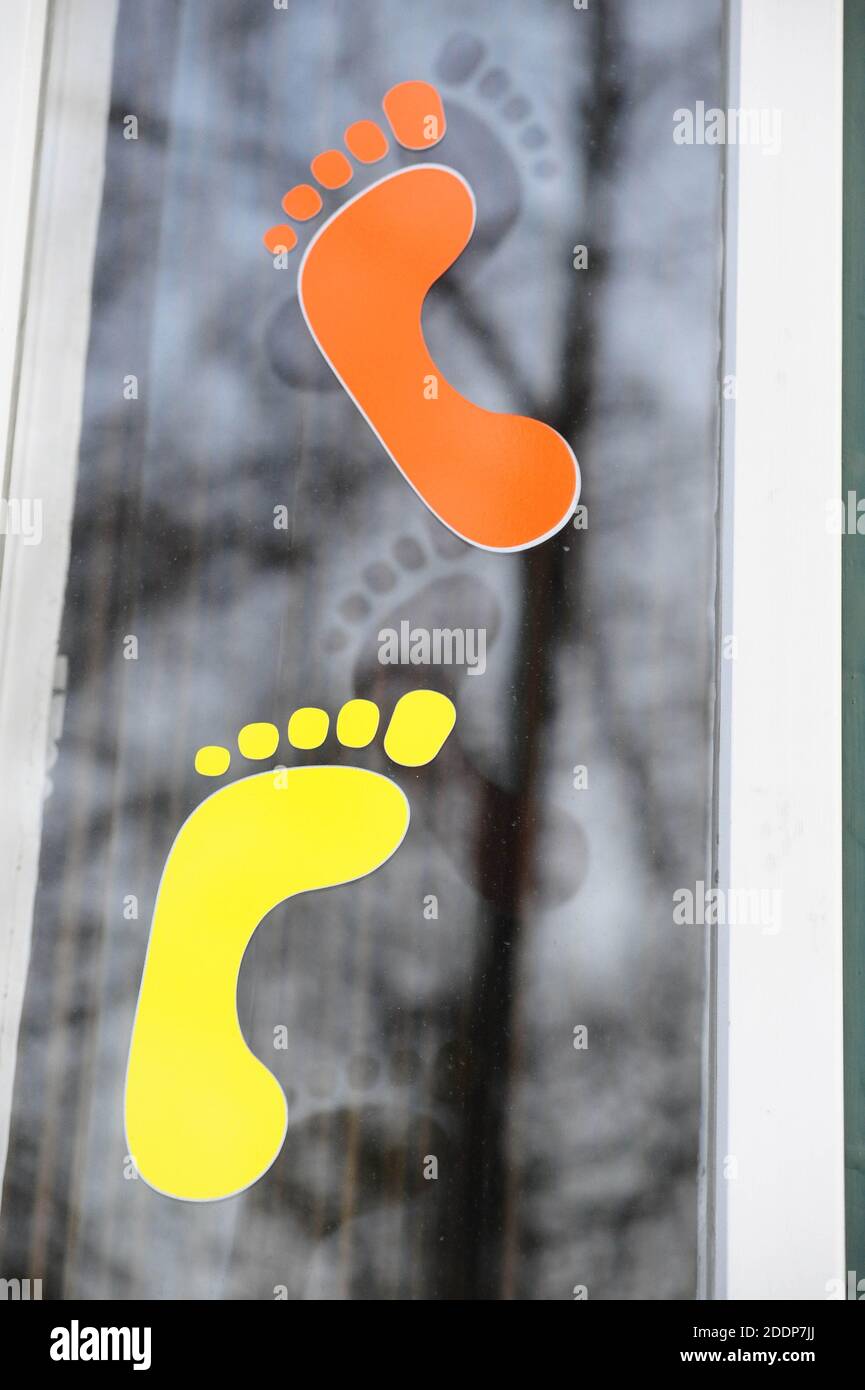 cut out yellow, orange and blue footprints on a window, barefoot symbol ...
