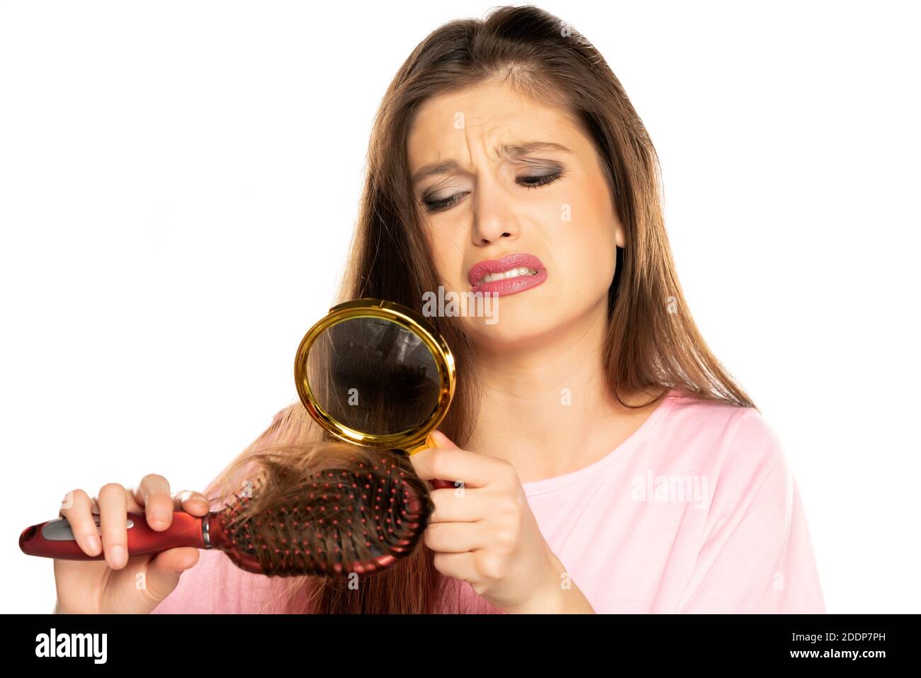 portrait of young nervous woman, looking her hair with magnifying glass ...