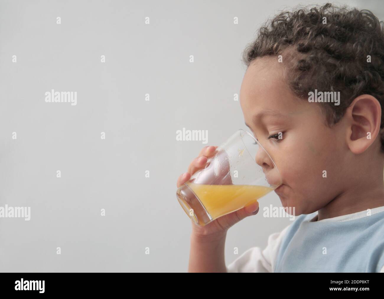 child drinking a glass of orange fruit juice promoting healthy eating ...