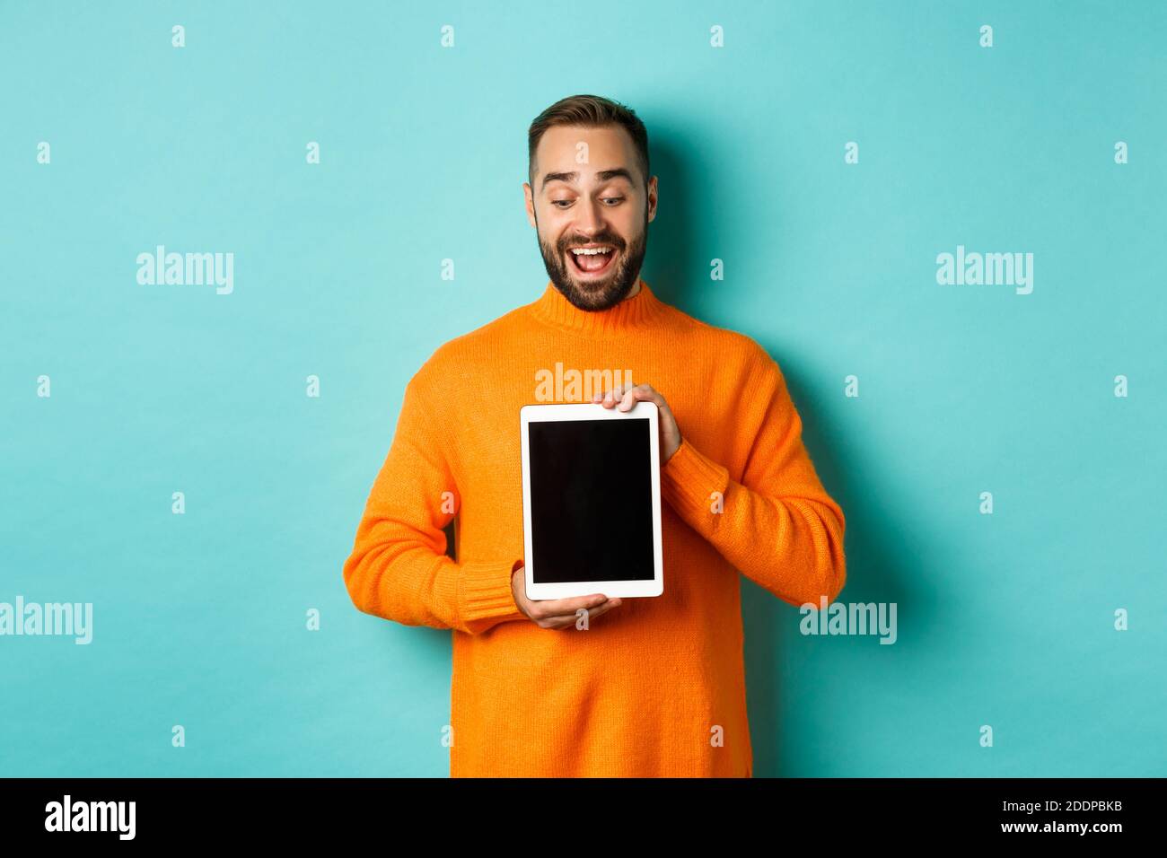 Technology. Cheerful adult man looking and showing digital tablet ...