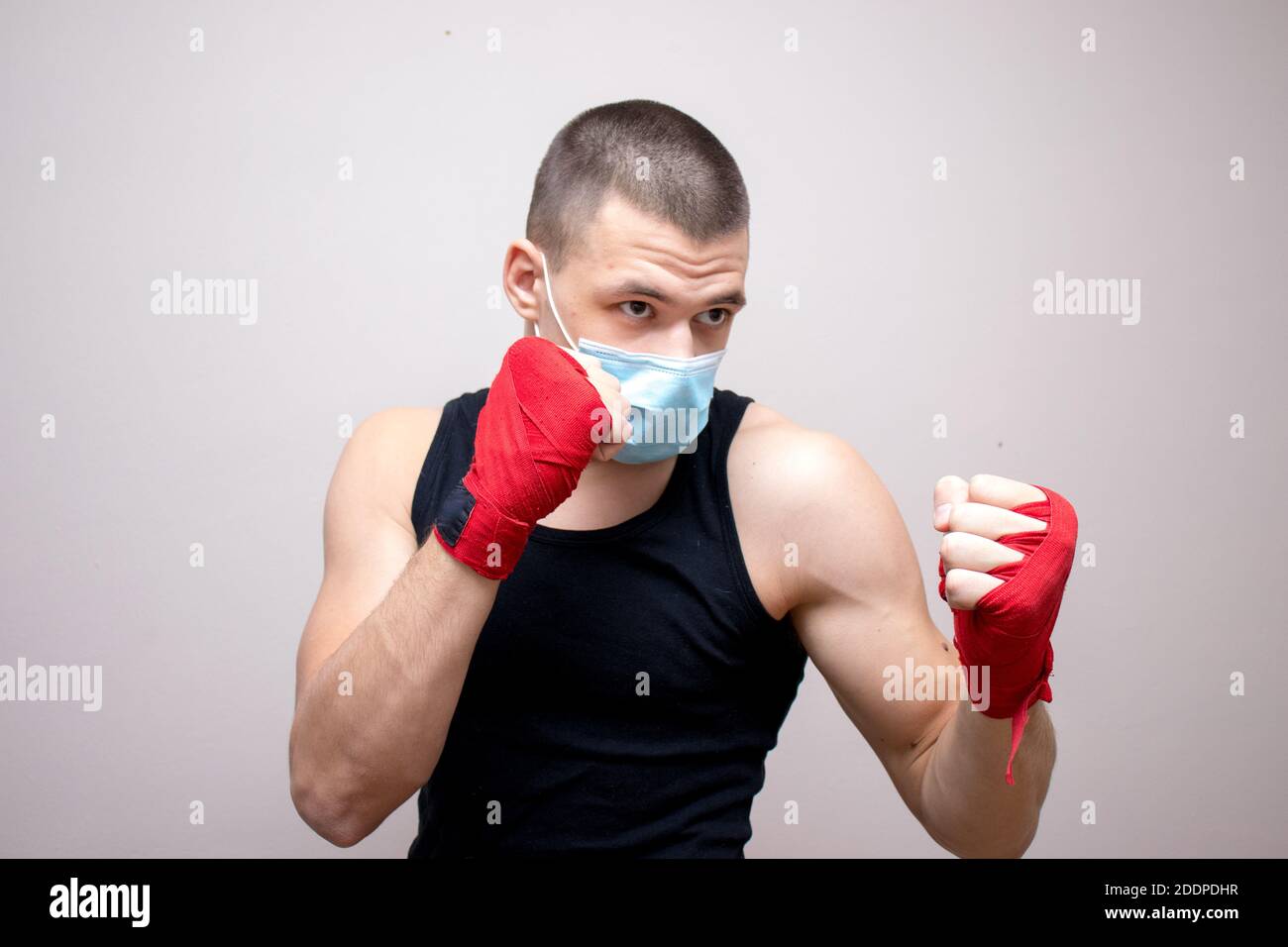 Young athletic male shadowboxing.Hand wrapped and wearing face mask ...