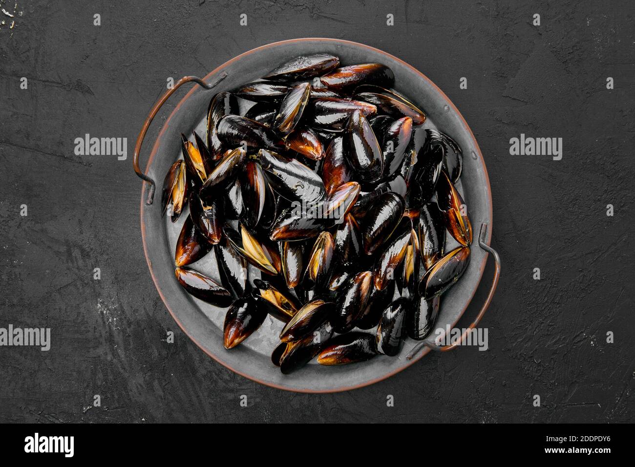 Big plate with frozen cooked whole shell mussels Stock Photo - Alamy