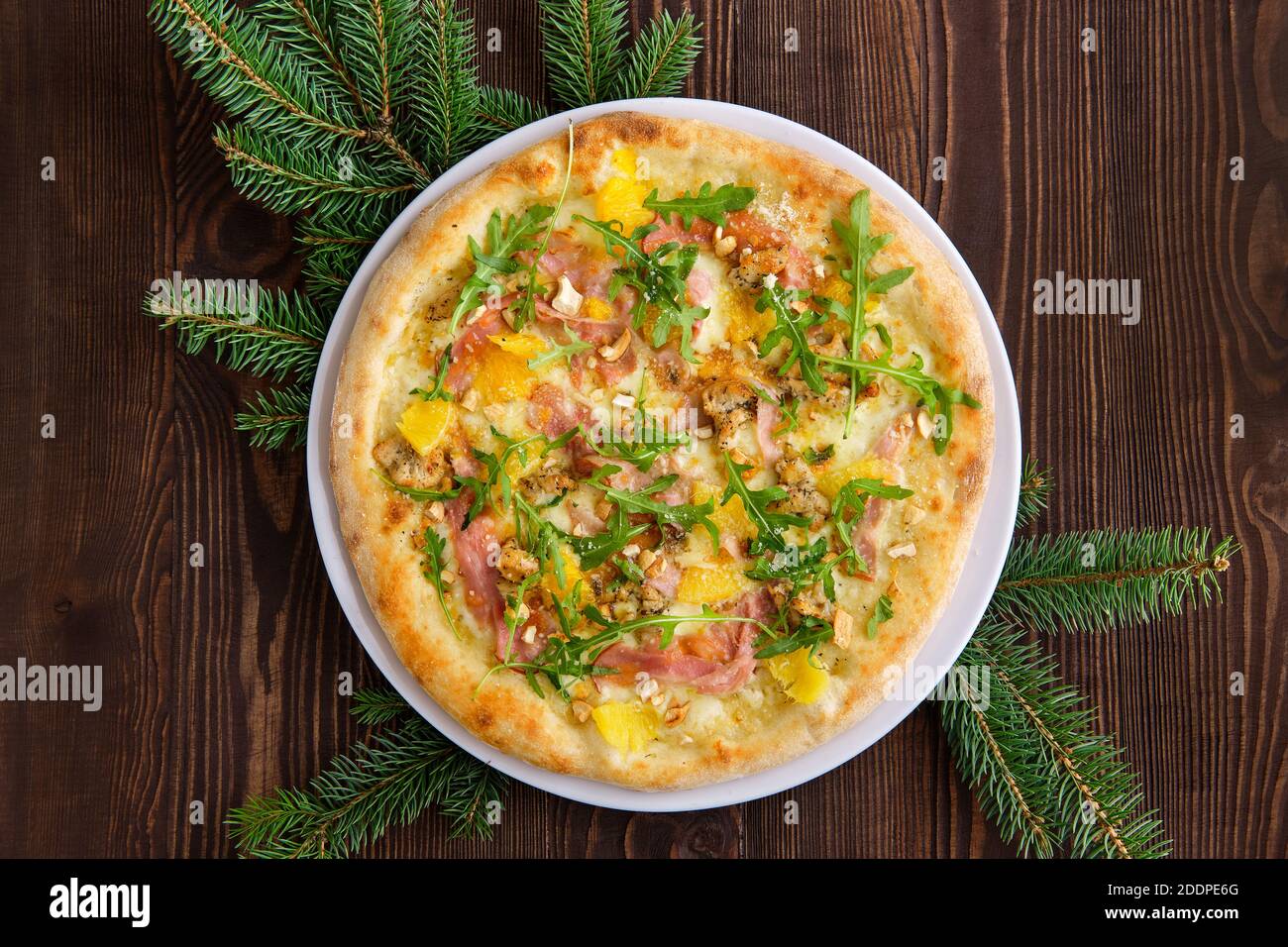 Pizza with turkey, bacon, orange and cashew nuts on dark wooden ...