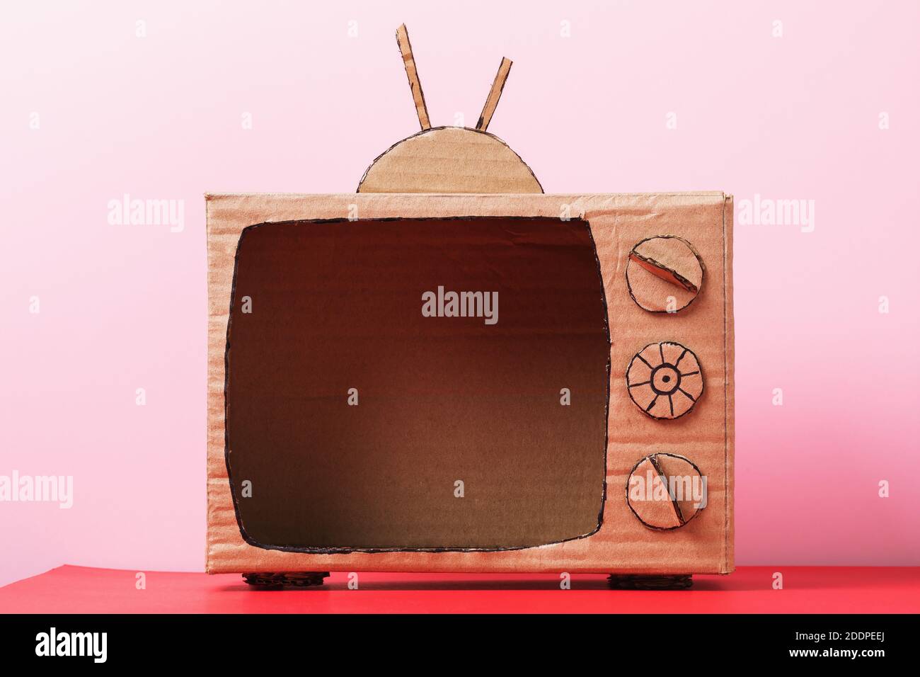 Blank cardboard TV on a pink background. Concept on the topic of ...