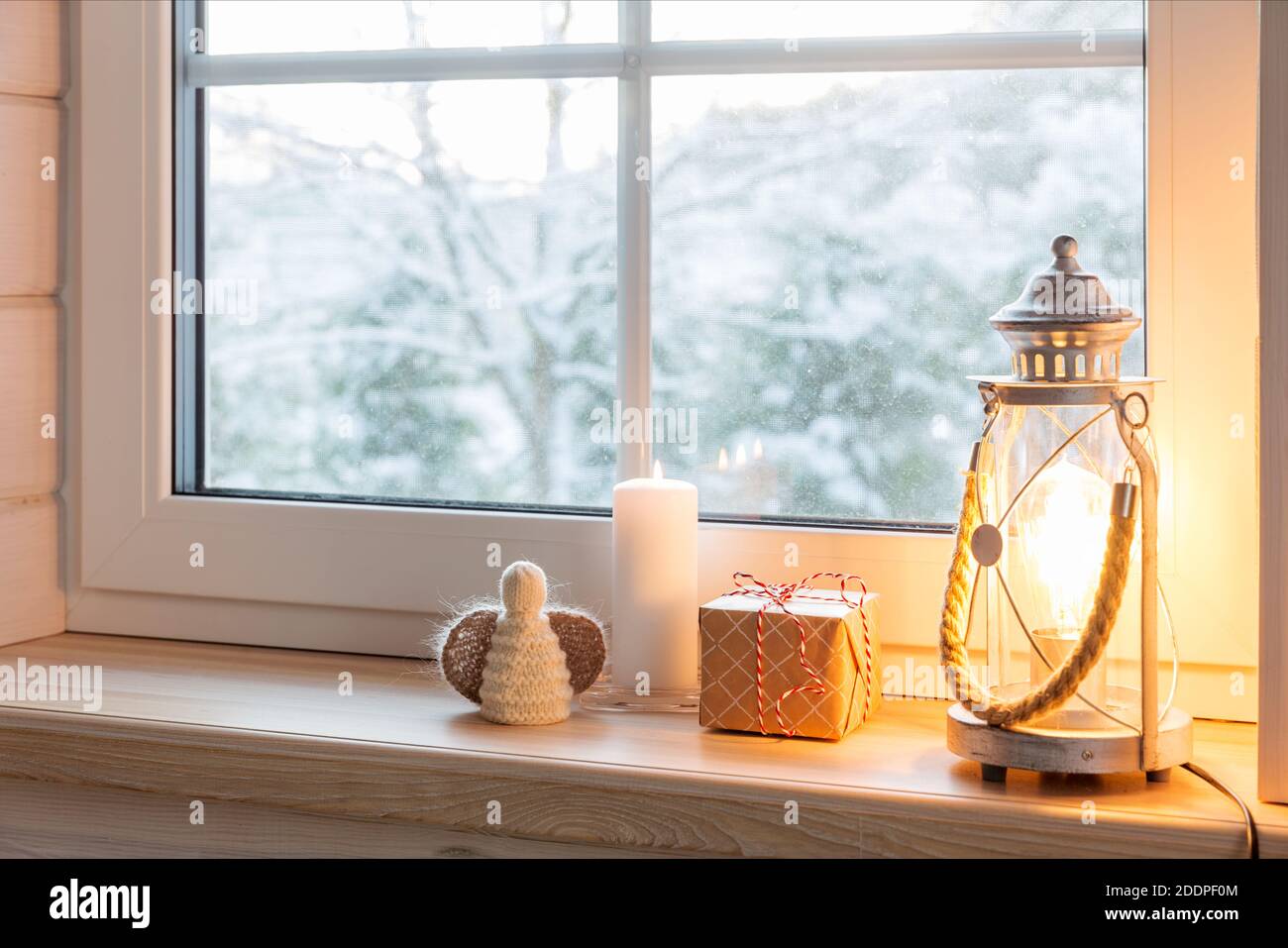 Christmas lantern, angels with gifts on the window of a wooden house ...