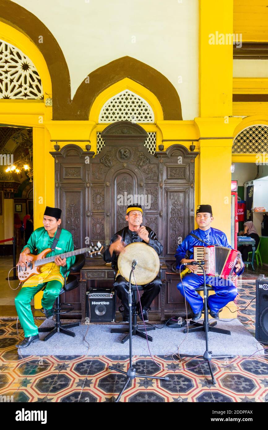 Musicians wearing traditional Indonesian wear at the Istana Maimun in ...