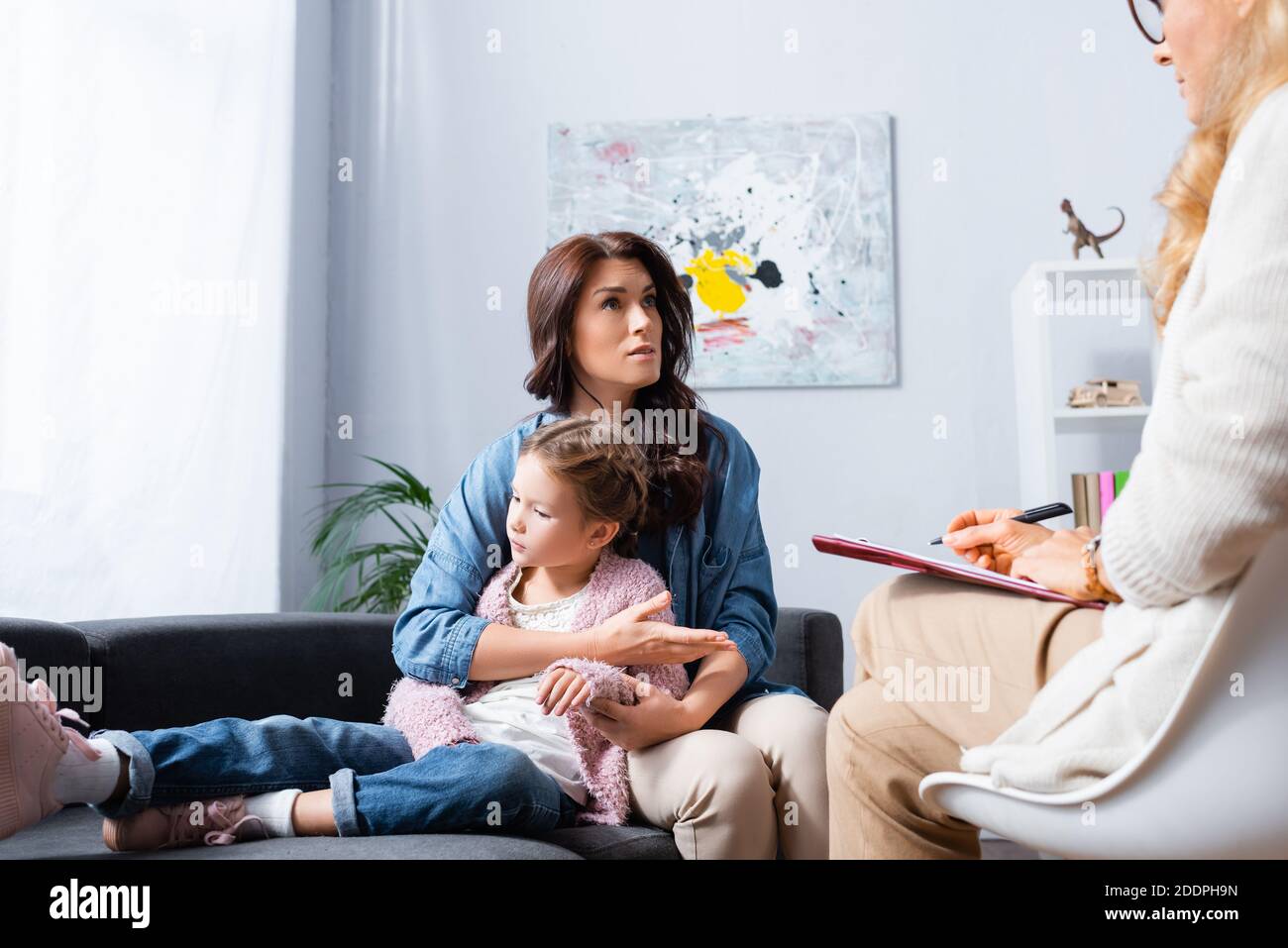 worried mother hugging daughter while visiting psychologist Stock Photo ...
