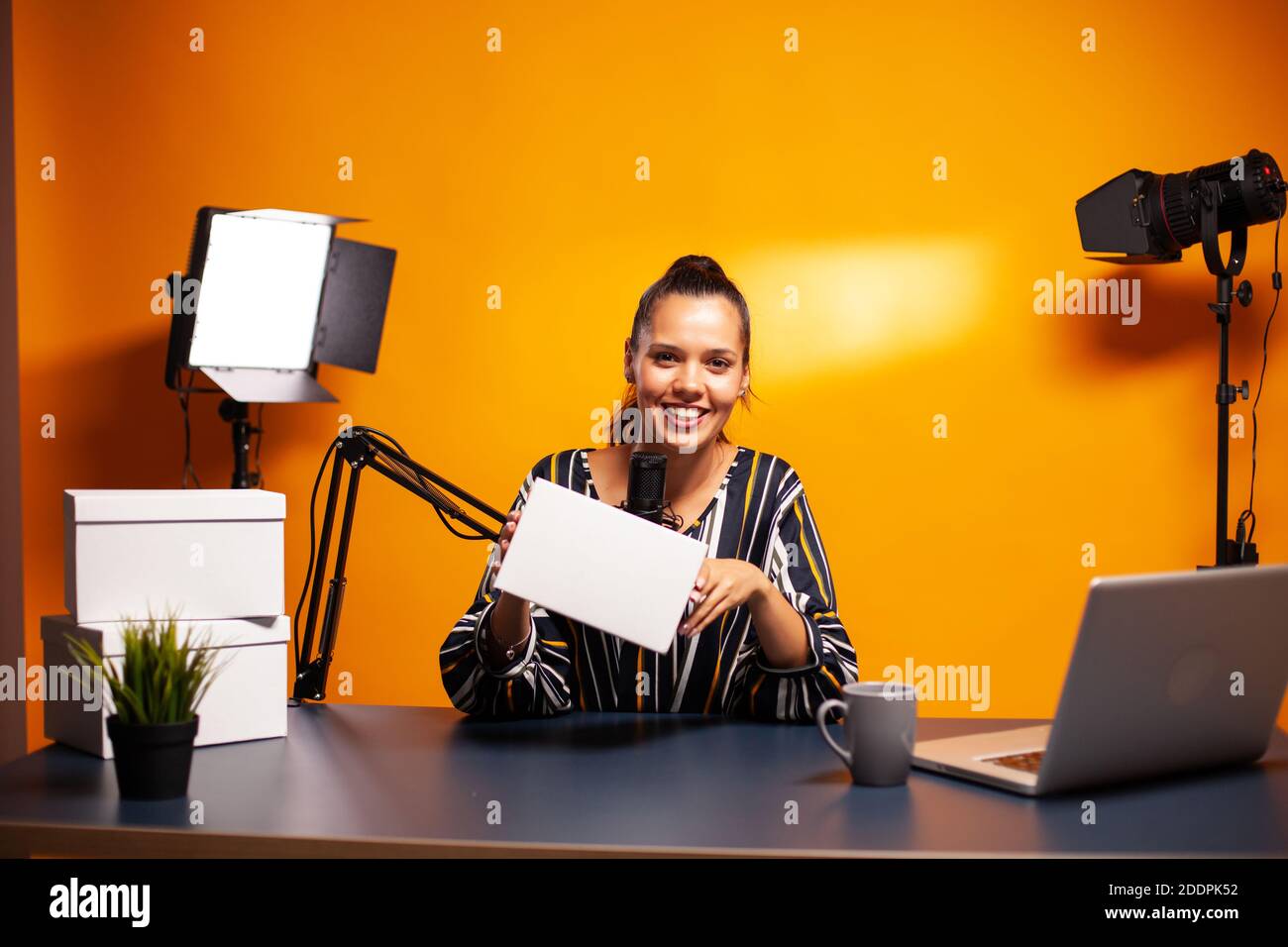 Influencer holding gift box while recording videoblog for social media ...