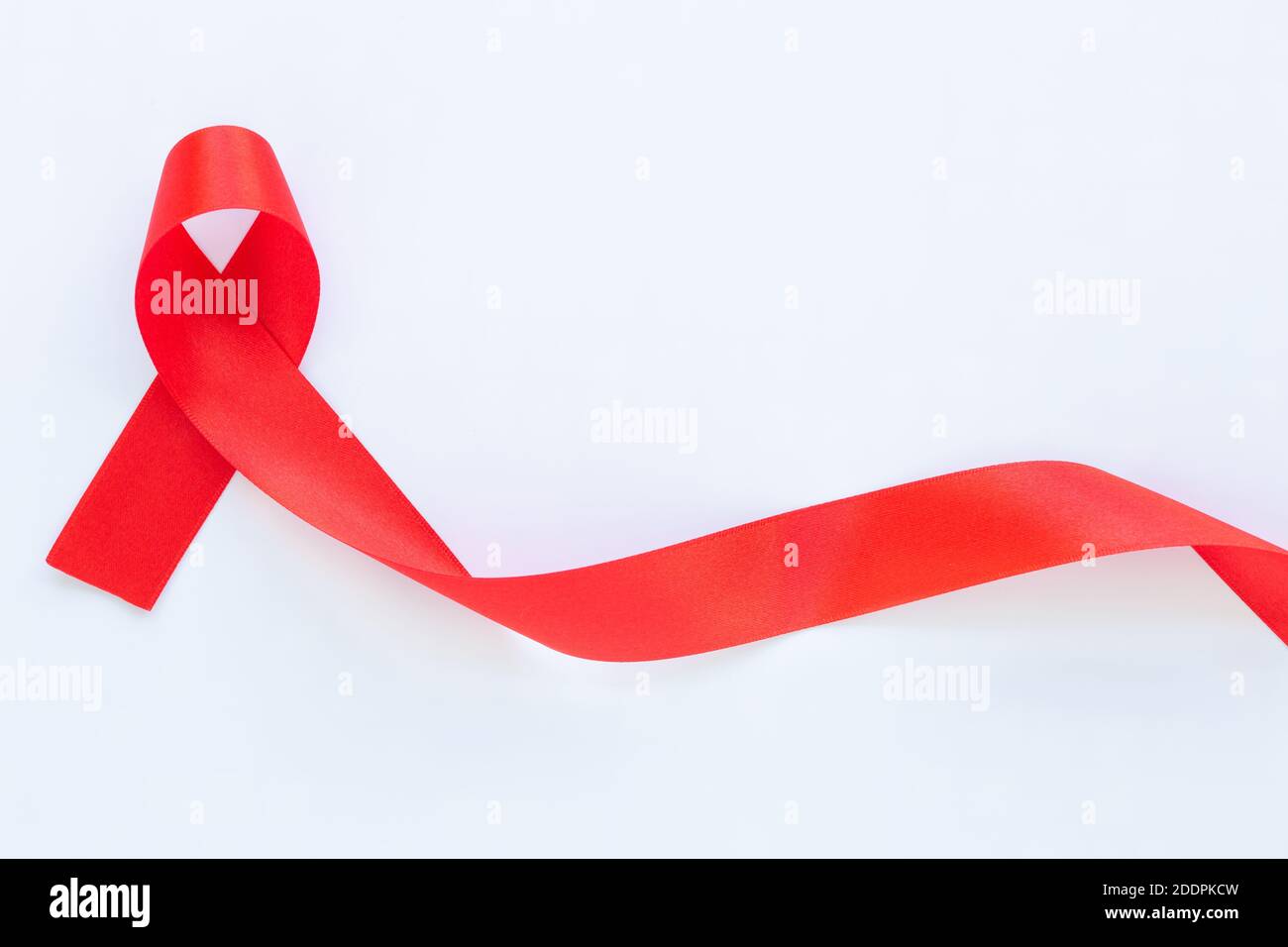 Red ribbon on white fabric background with copy space, symbol for the solidarity of people ...
