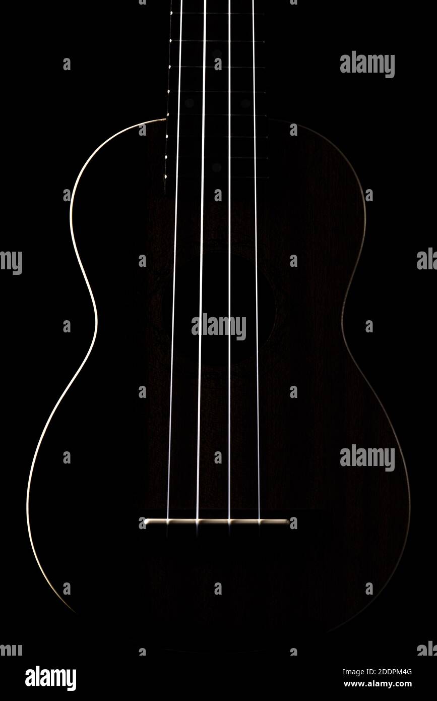 Brown guitar ukulele front view silouette close up dark background ...