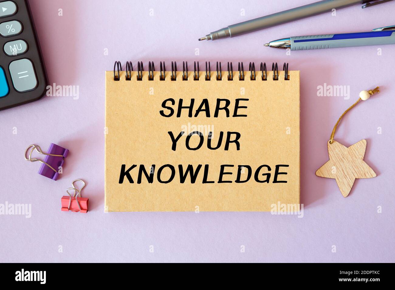 SHARE YOUR KNOWLEDGE is written on a notepad on an office desk with ...