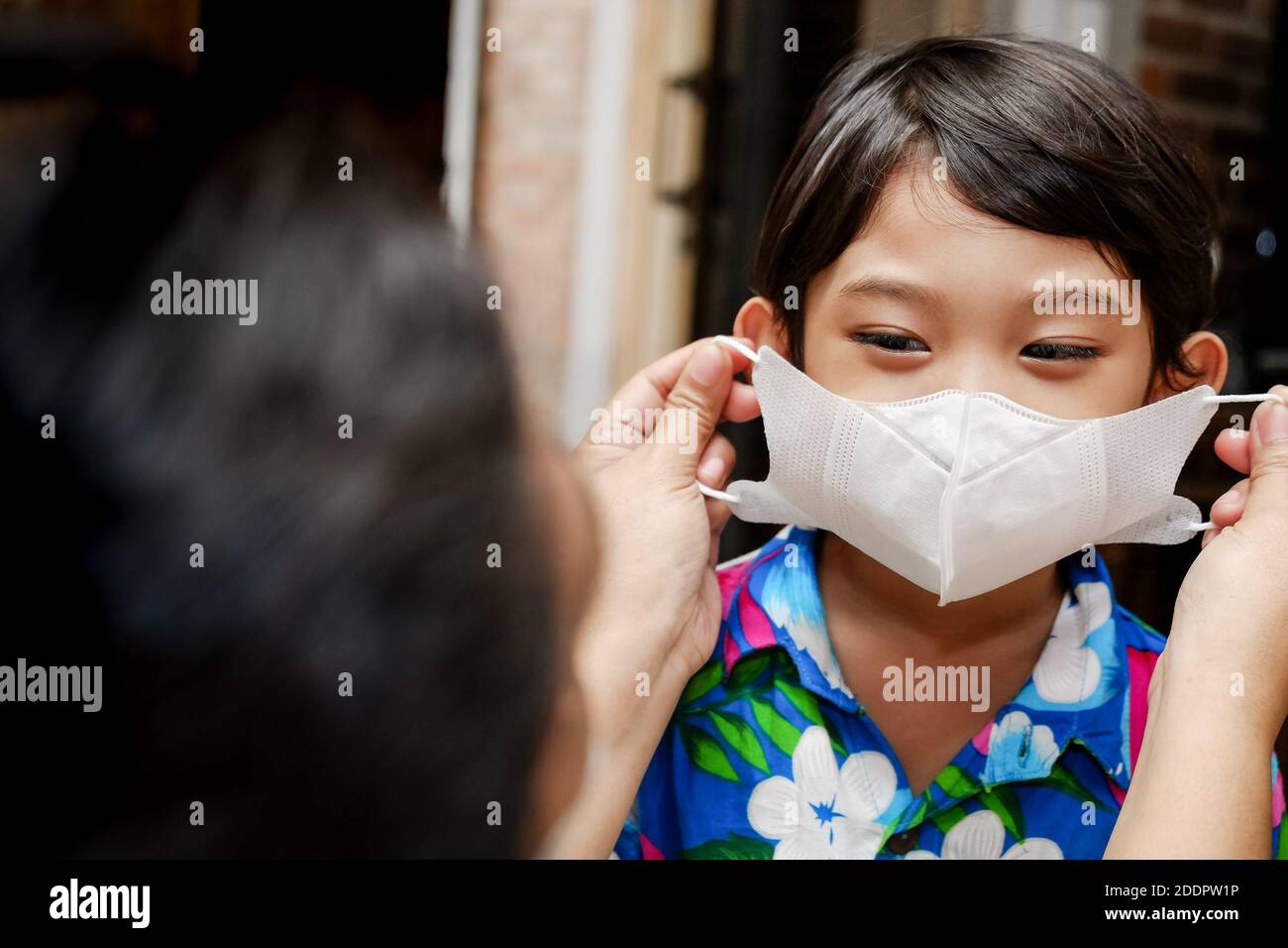 Southeast Asian mother helping little boy using face mask Stock Photo ...