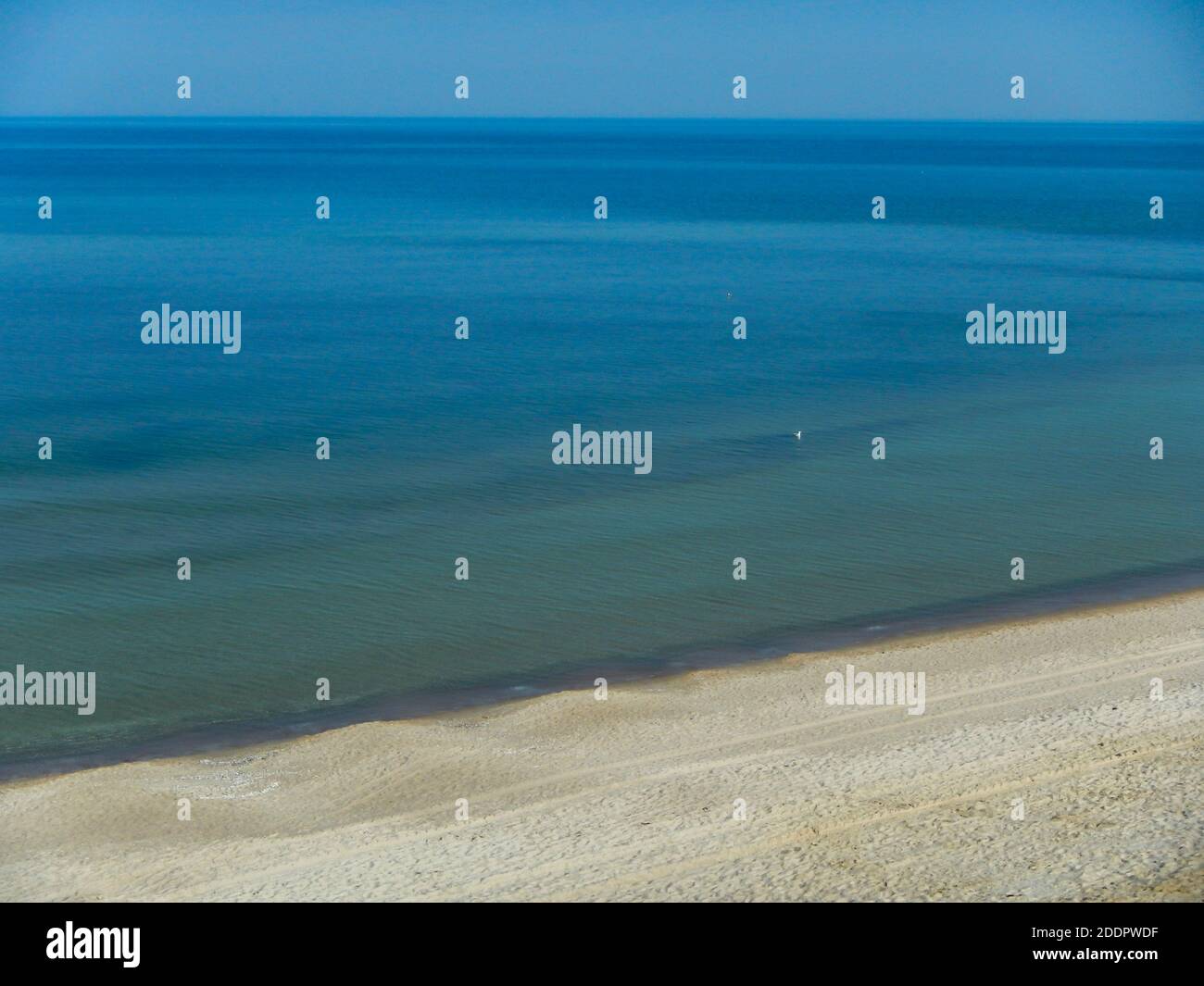 View of a very calm sea, beach and breakwater Stock Photo - Alamy