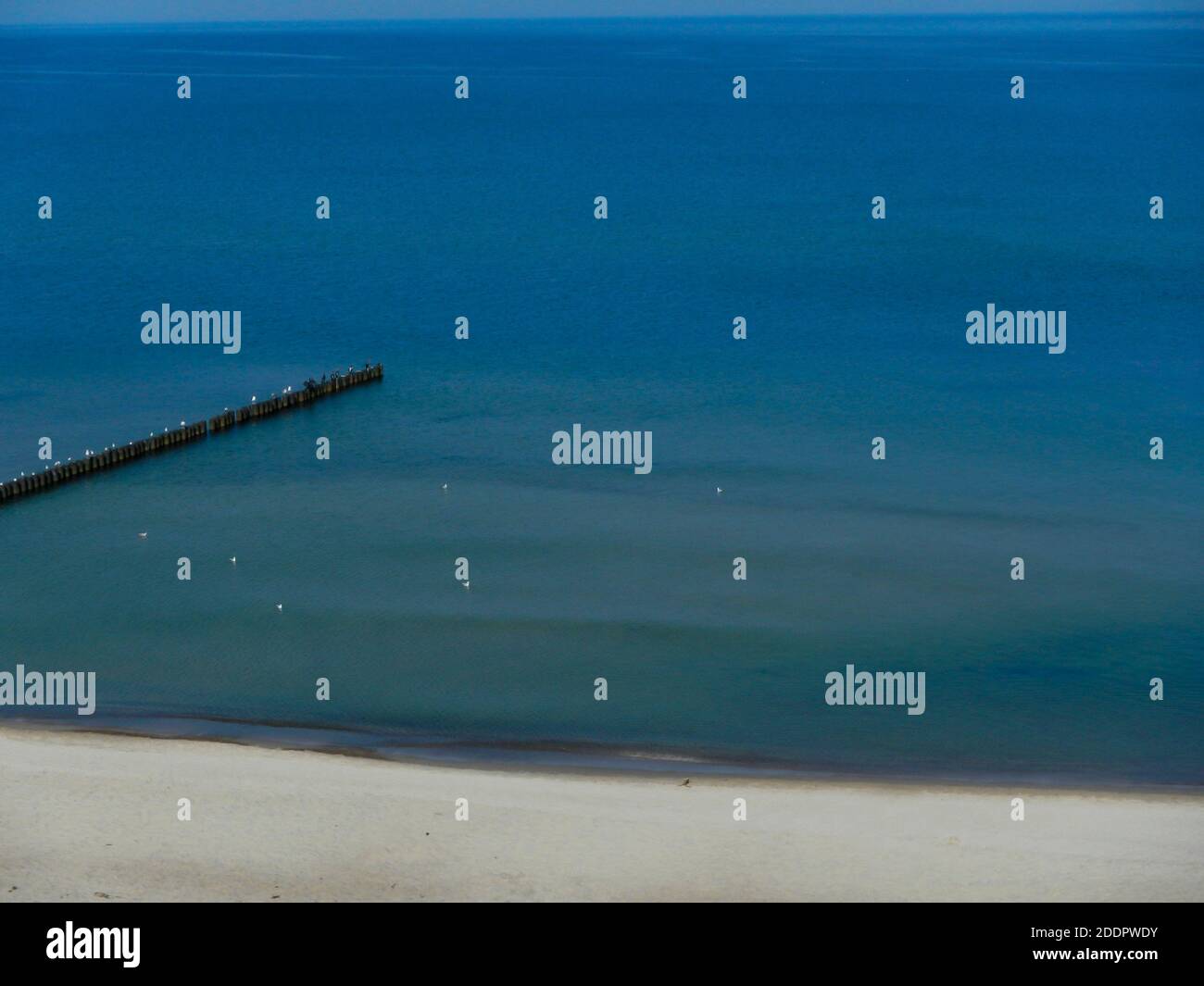 View of a very calm sea, beach and breakwater Stock Photo - Alamy