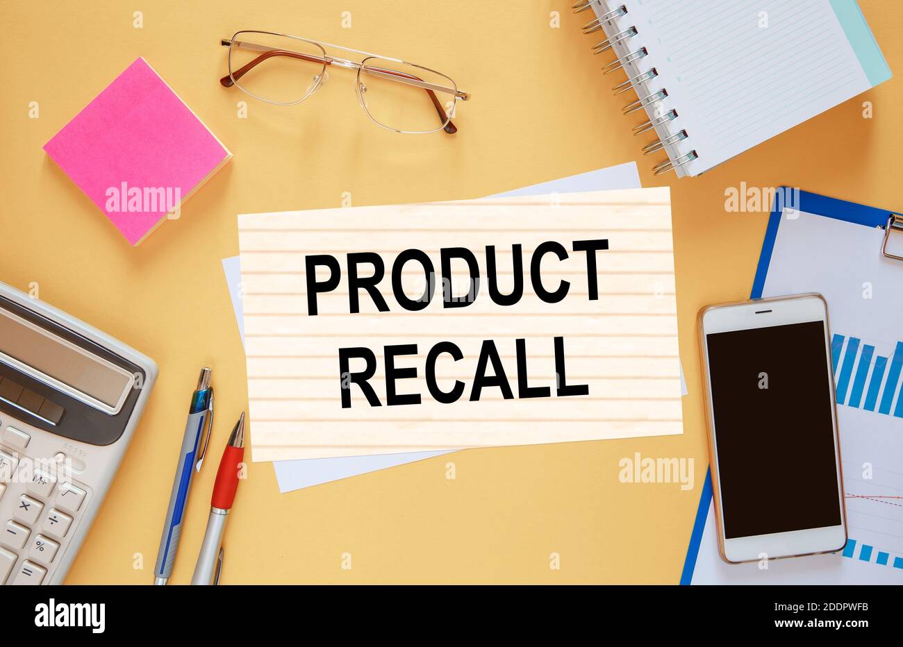 Paper with the text PRODUCT RECALL on the office table among the ...