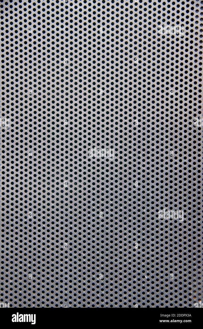 Perforated metal mesh as a texture or background in portrait format ...