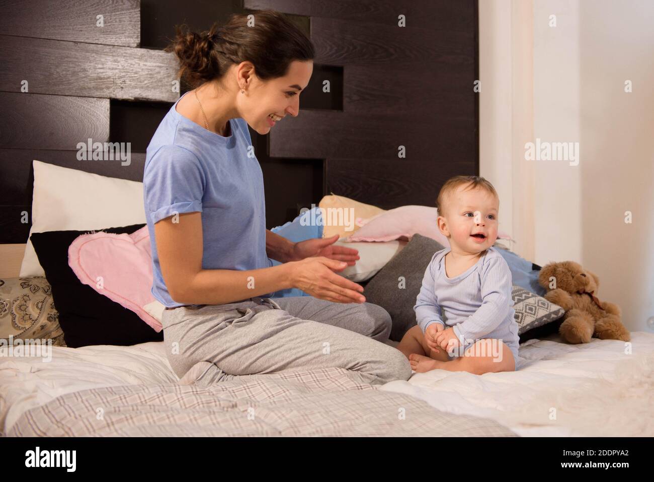 Mother with her cute little son playing on bed Stock Photo - Alamy