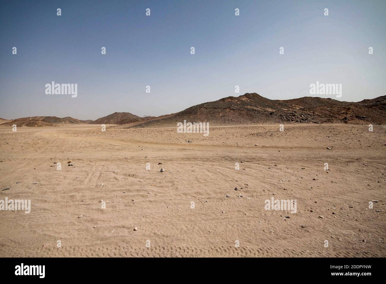 View of a sunny sandy desert with mountains and pyramids in the ...