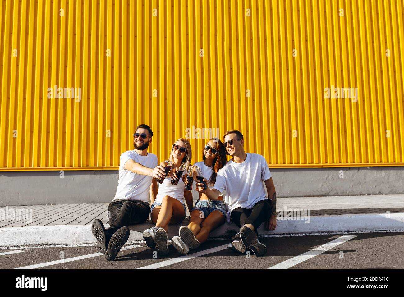 A group of young friends guys and girls hanging out in the city ...