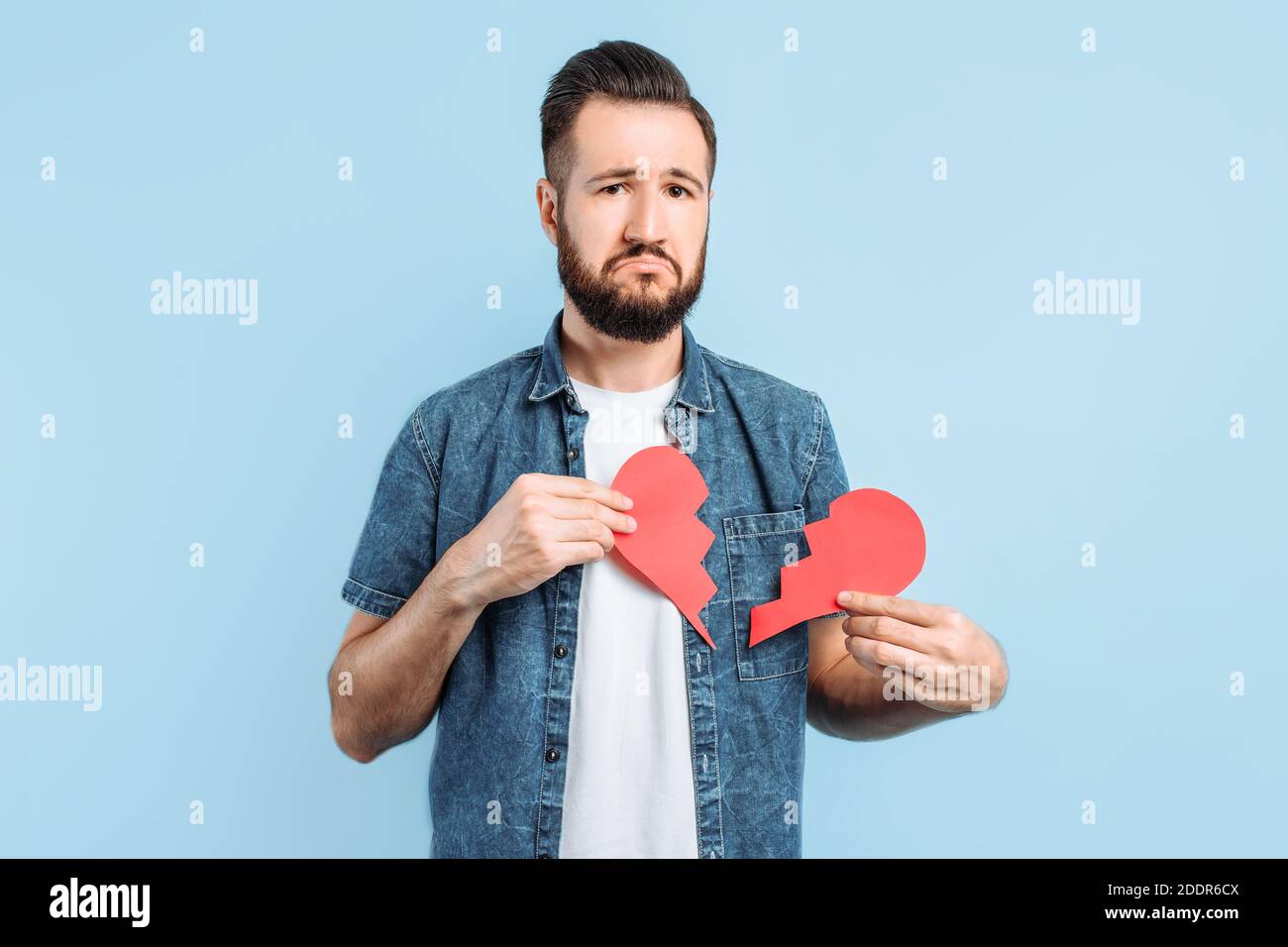 A restless sad confused man holding a broken heart in his hands ...