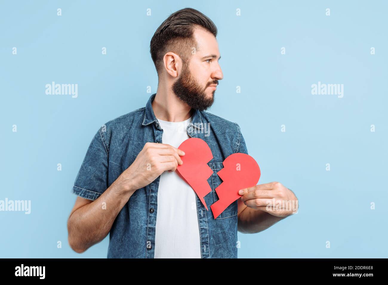 A restless sad confused man holding a broken heart in his hands ...