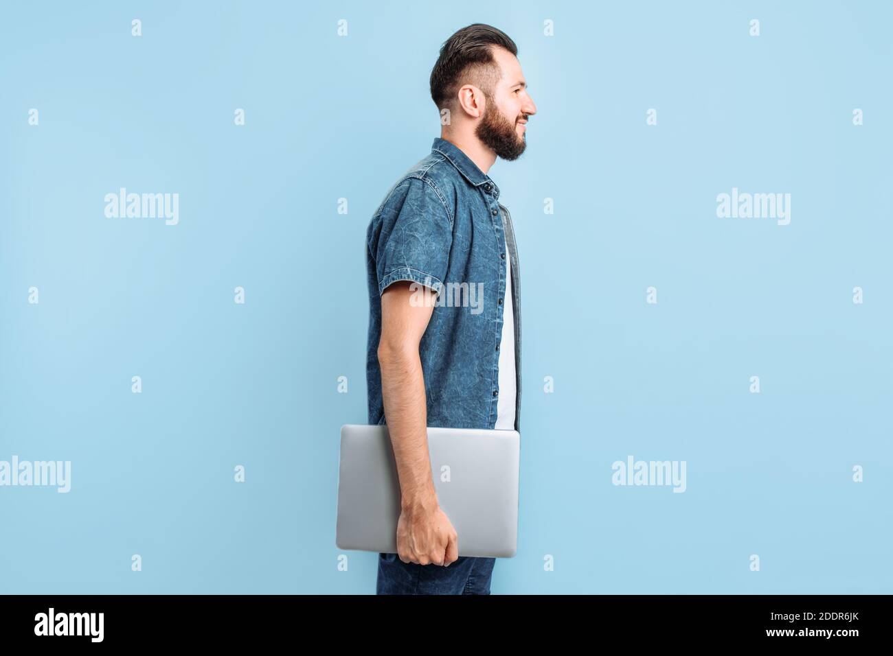 Photo of a handsome man with a beard in casual clothes, holding a ...