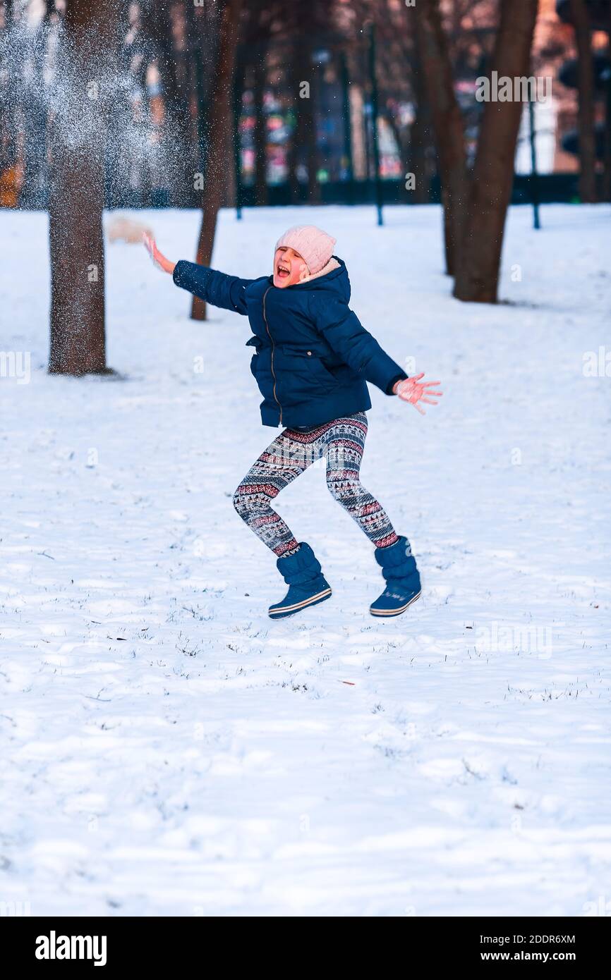Happy teenage girl having a snowball fight, ready to throw a snowball ...
