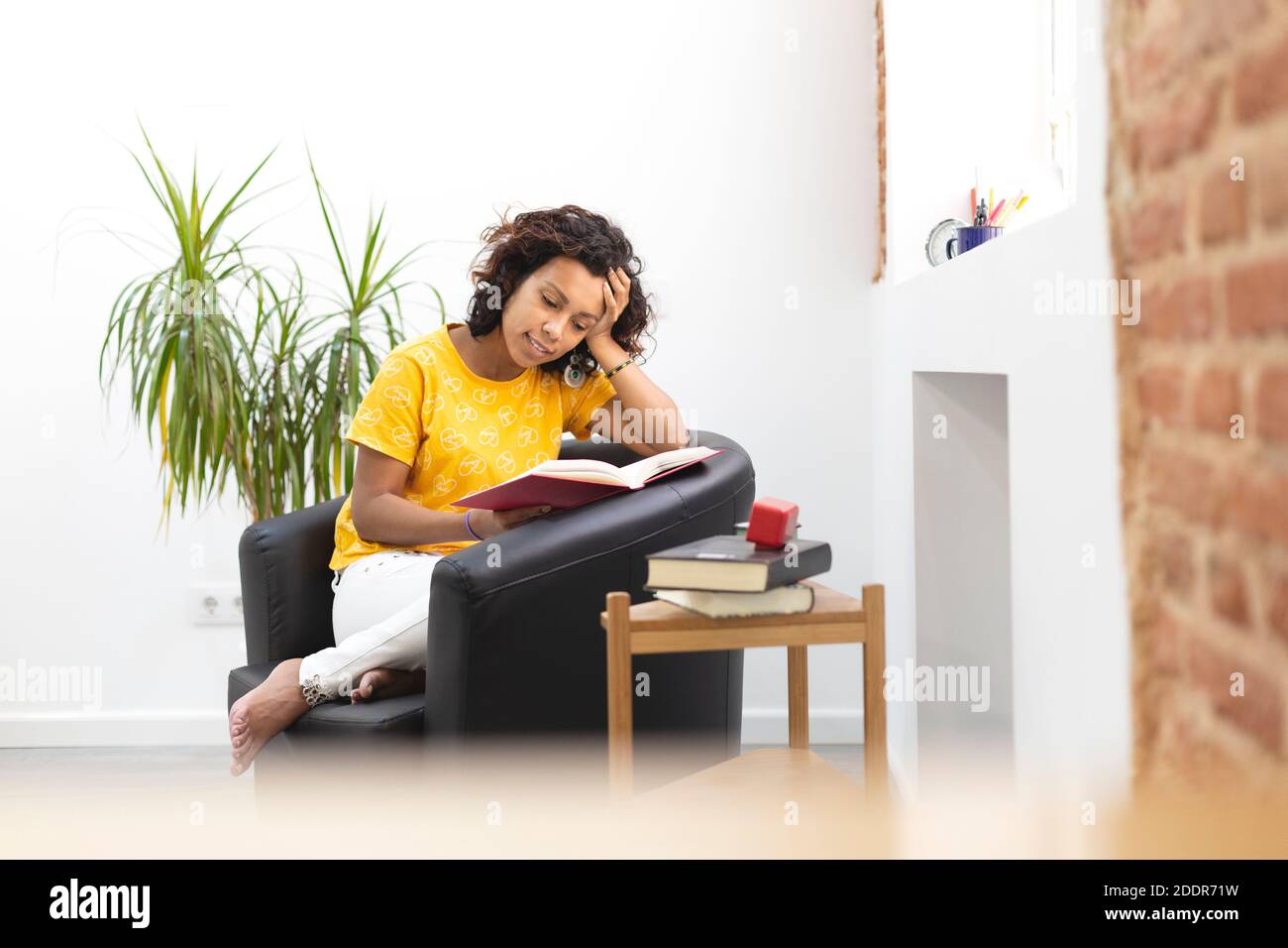Portrait of a beautiful woman reading a book at home. Space for text ...