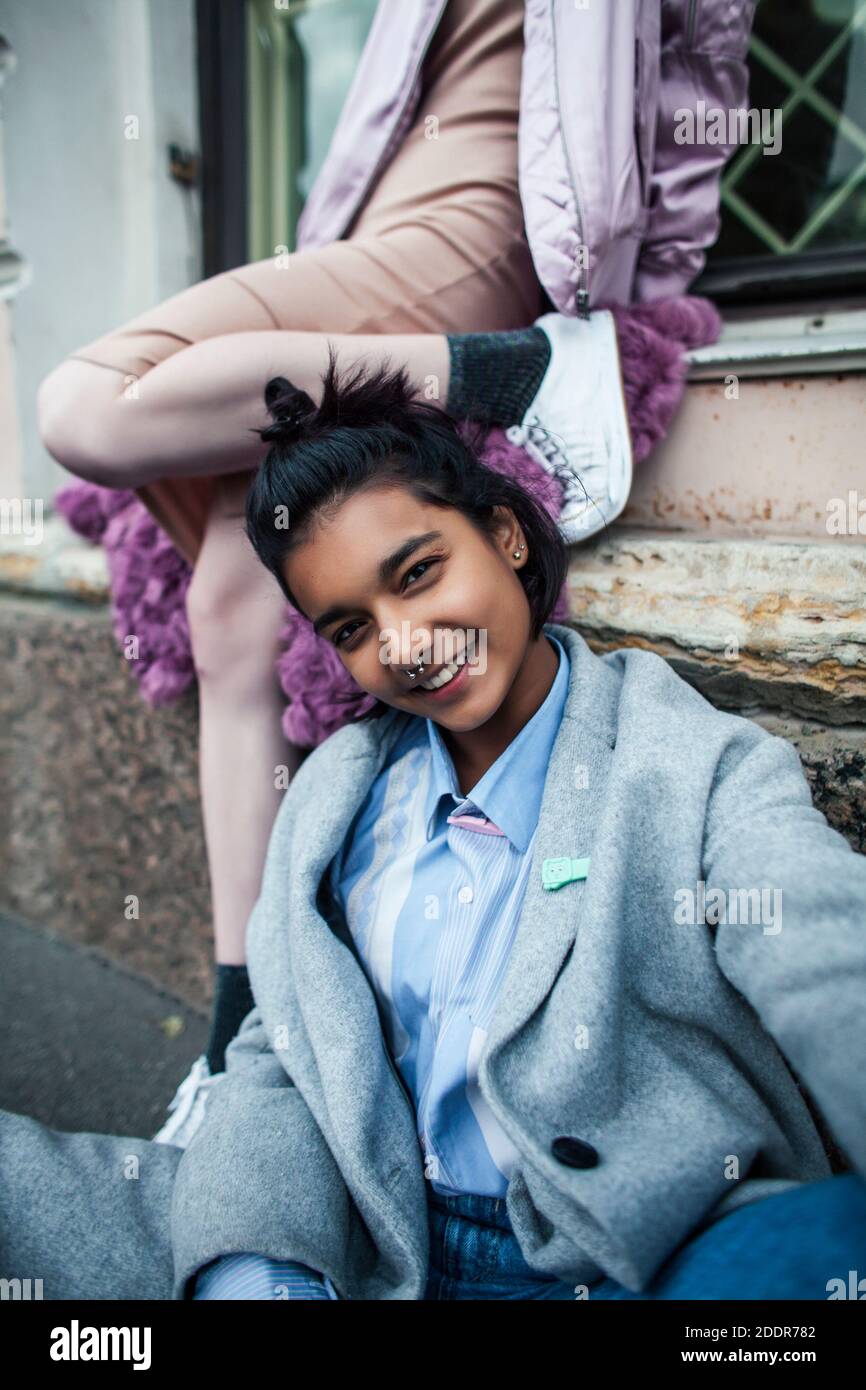 Two teenage girls infront of university building smiling, having fun ...