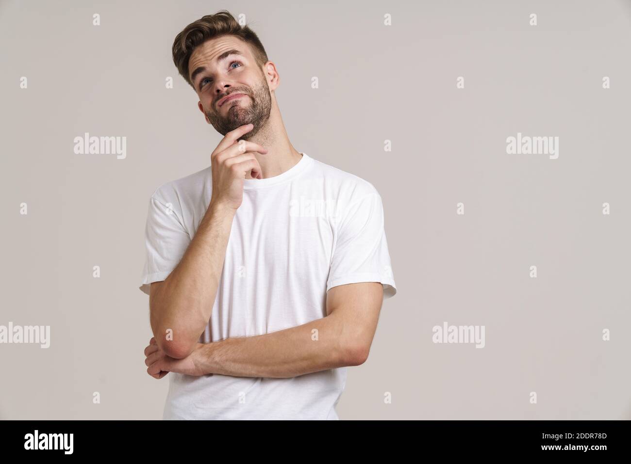 Confused handsome unshaven guy thinking and looking upward isolated ...