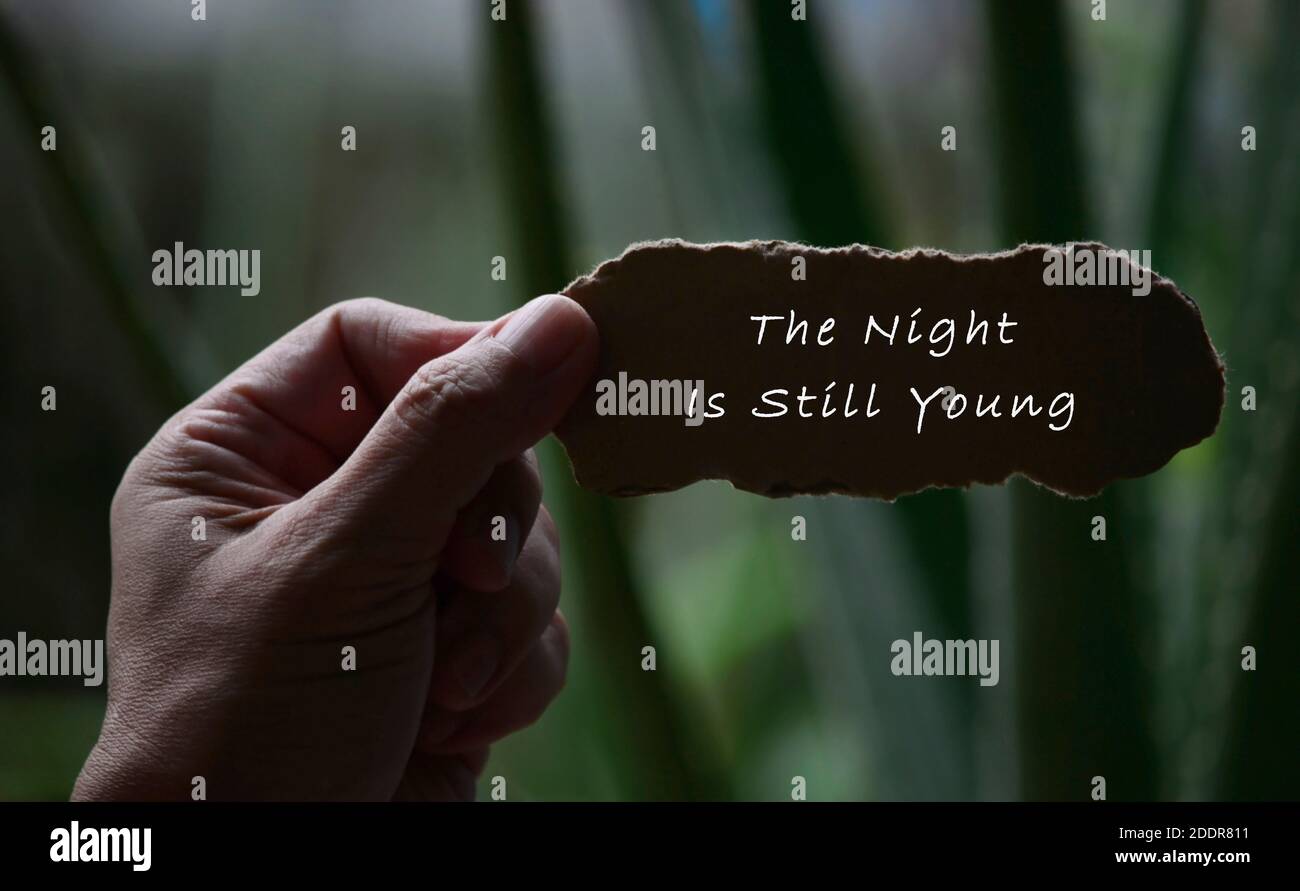 Hands holding torn paper with motivational quote and blurred dark ...