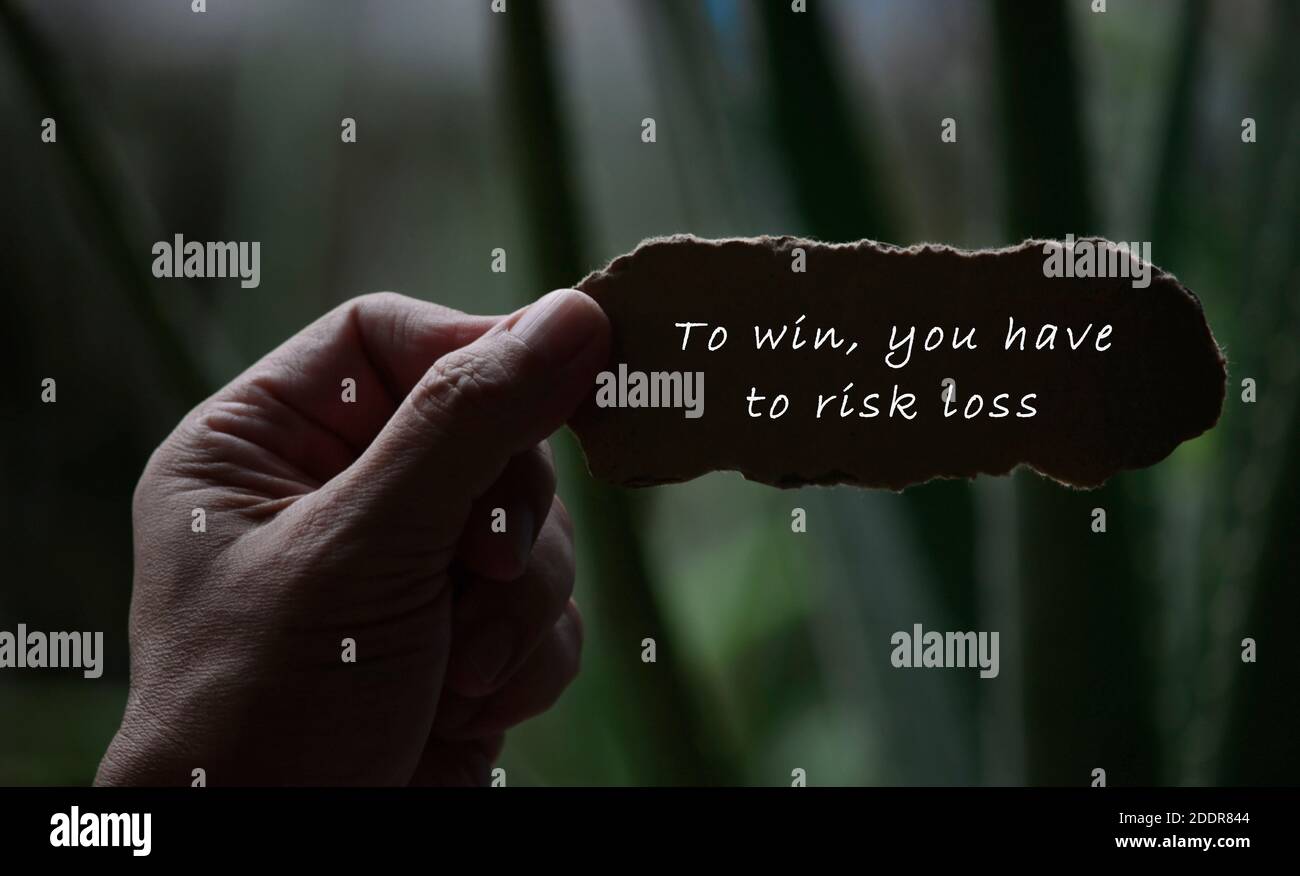 Hands holding torn paper with motivational quote and blurred dark ...