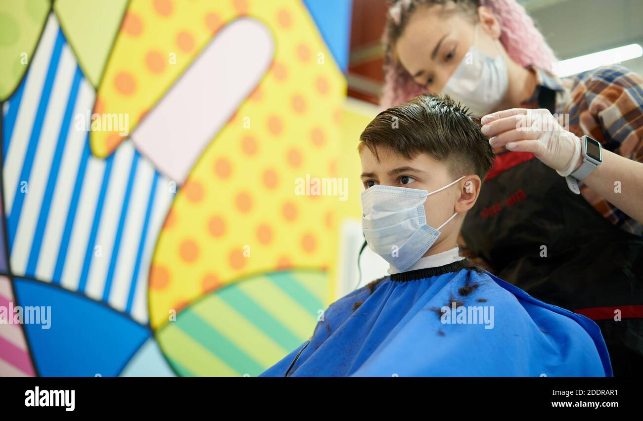 Teenager wearing face mask at barber shop during pandemic Stock Photo ...