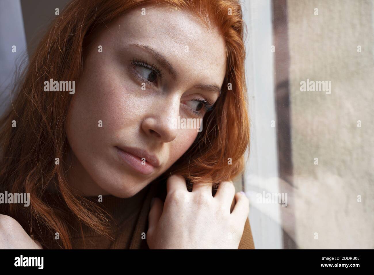 Young worried woman looking out of the window Stock Photo - Alamy