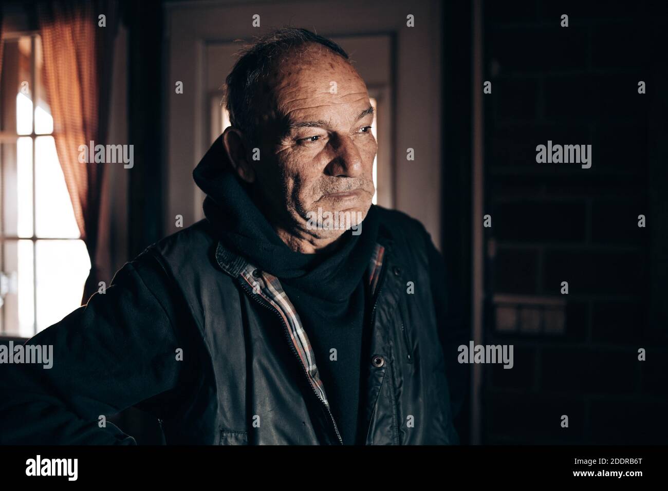 Elderly man looking through the window, pensive, worried Stock Photo ...