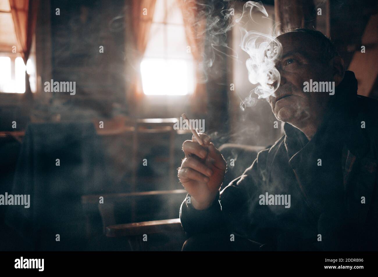 Elderly man smoking. Copy space. Dark light, atmospheric, real life ...