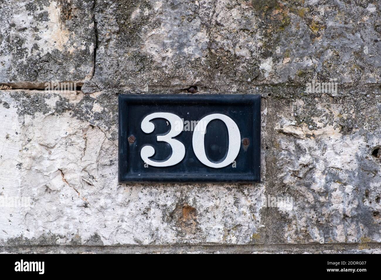 Street number thirty. Digit 30 white color on metal vintage plate ...