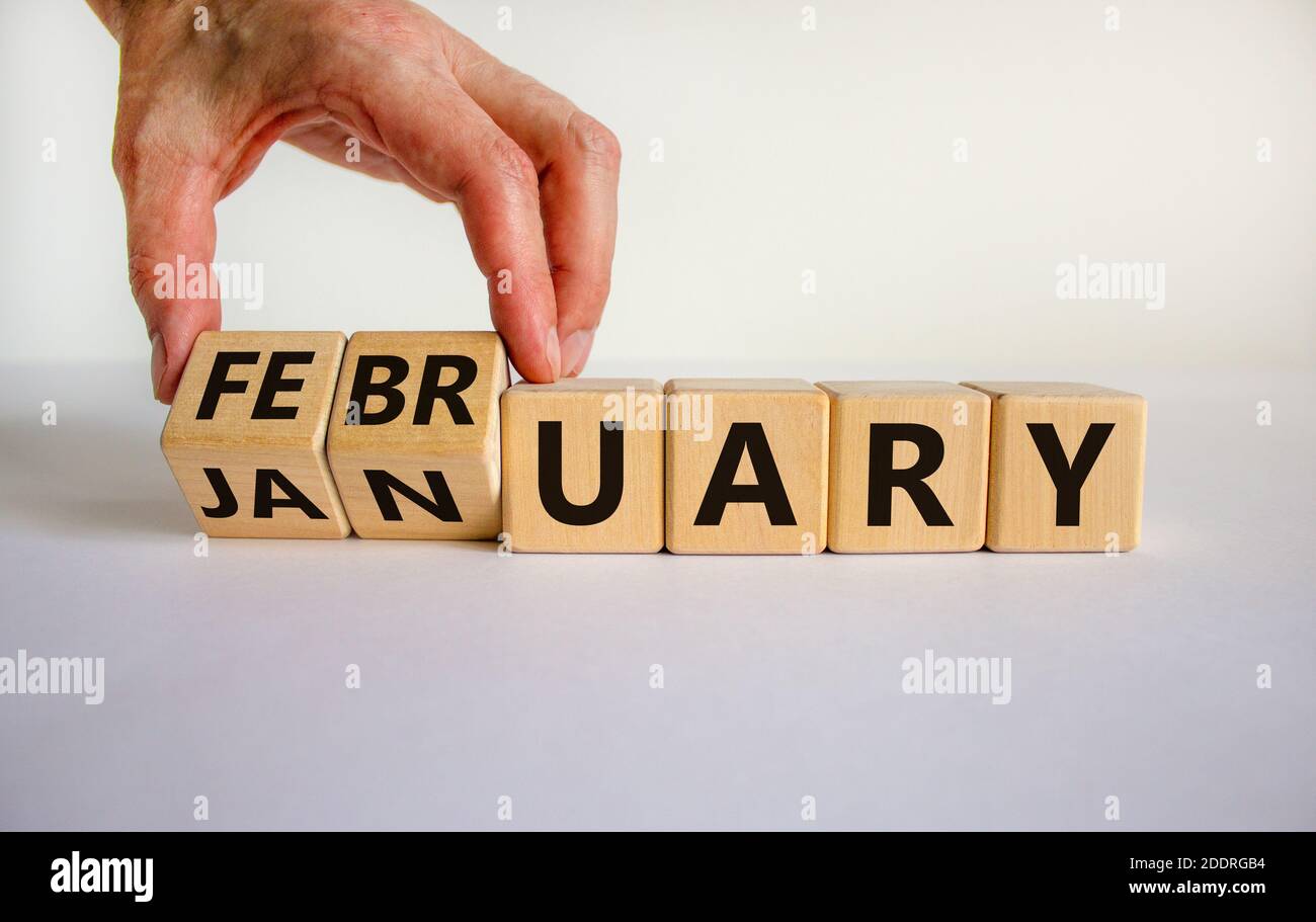 Symbol for the change from January to February. Male hand flips wooden ...