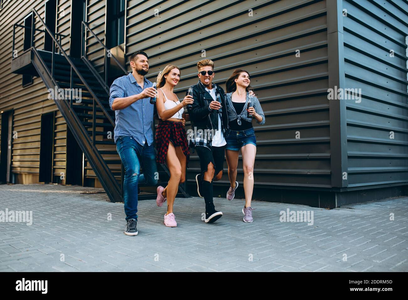 A group of young friends, girls and guys walking together in the fresh ...
