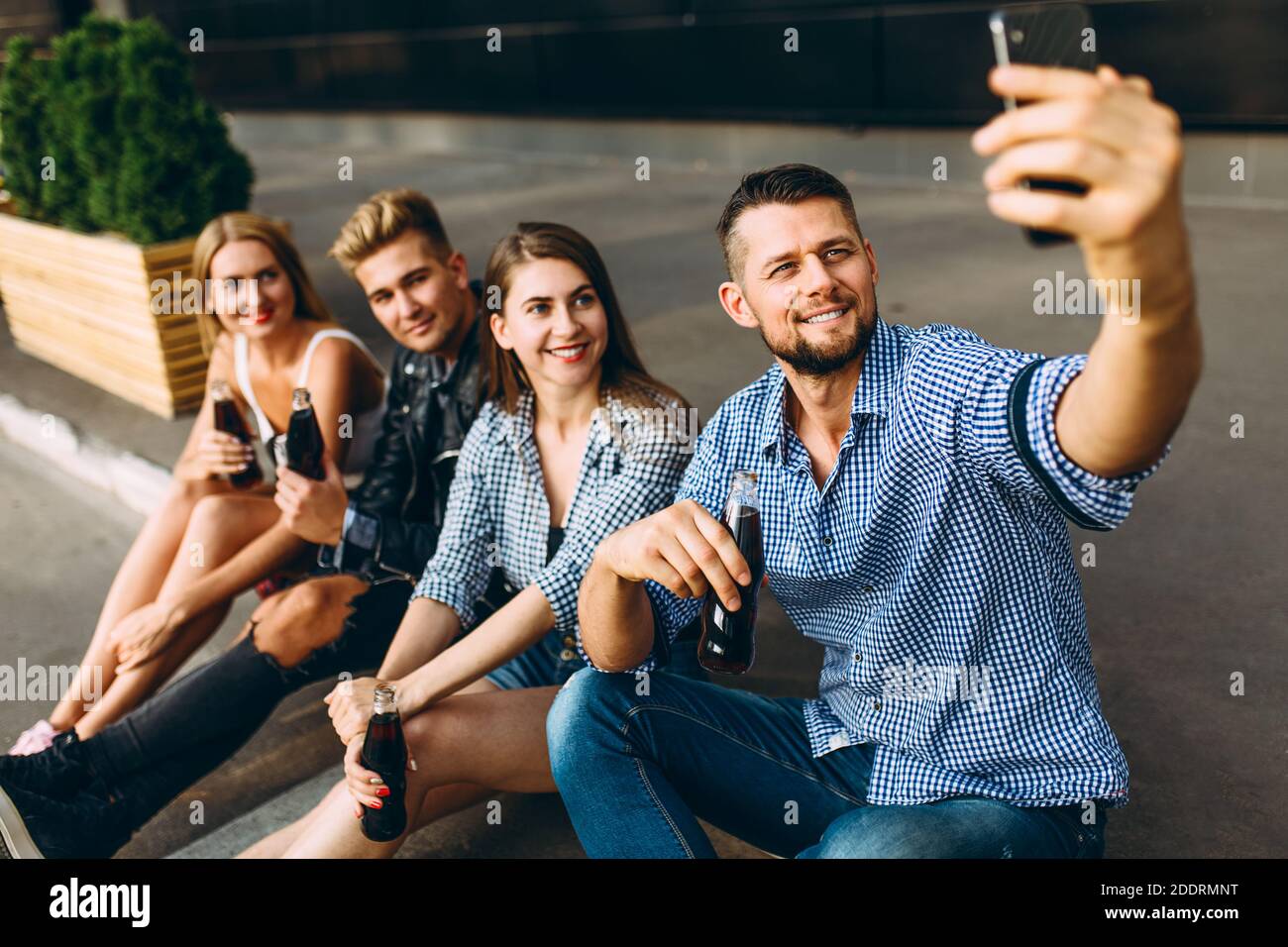 A group of cheerful friends, boys and girls walk around the city ...