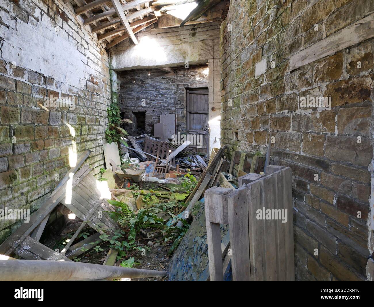 Old dilapidated farm building with wood and other items scattered ...