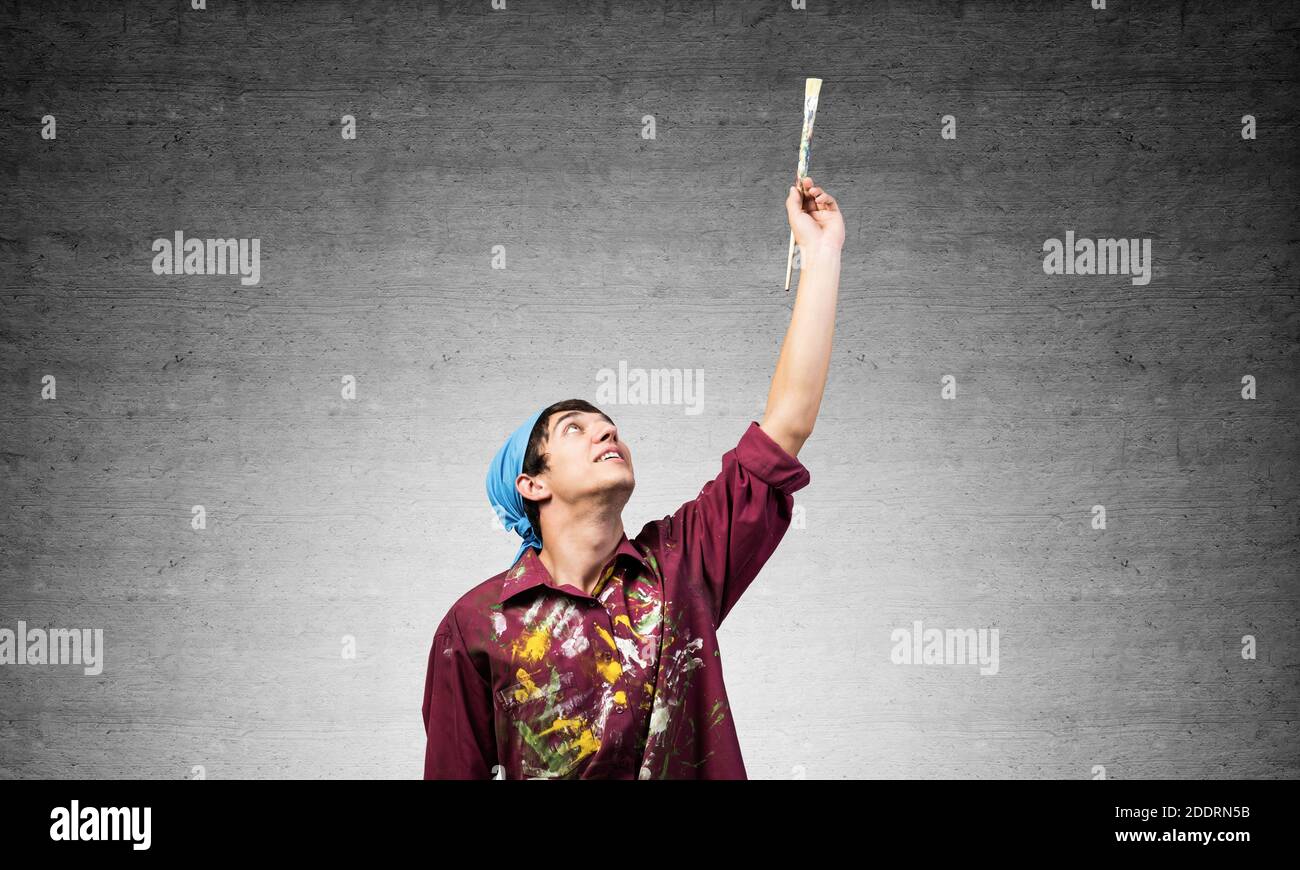 Young painter artist pointing upwards Stock Photo - Alamy